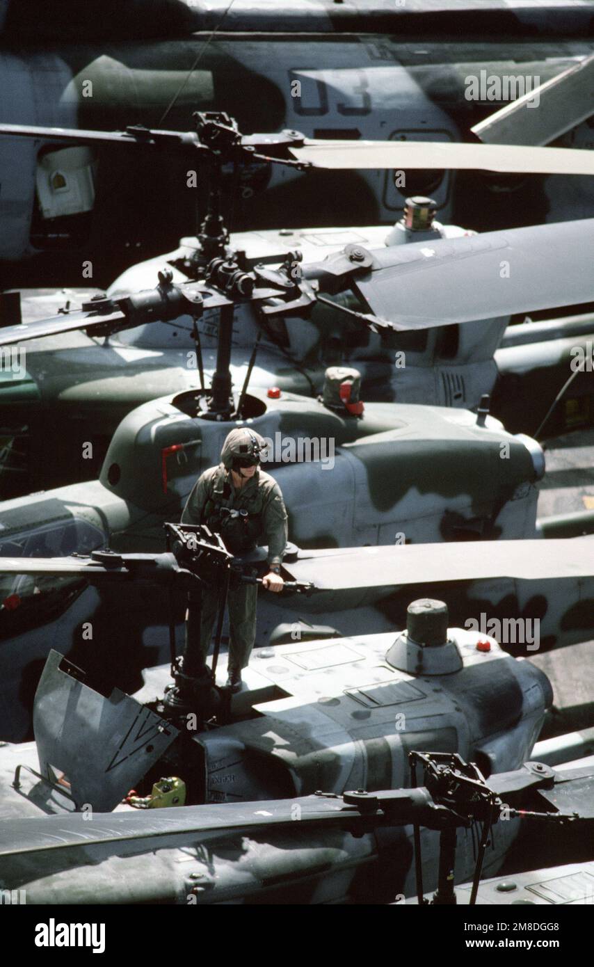 A Marine flight crewman checks the main rotor of a UH-1N Iroquois ...