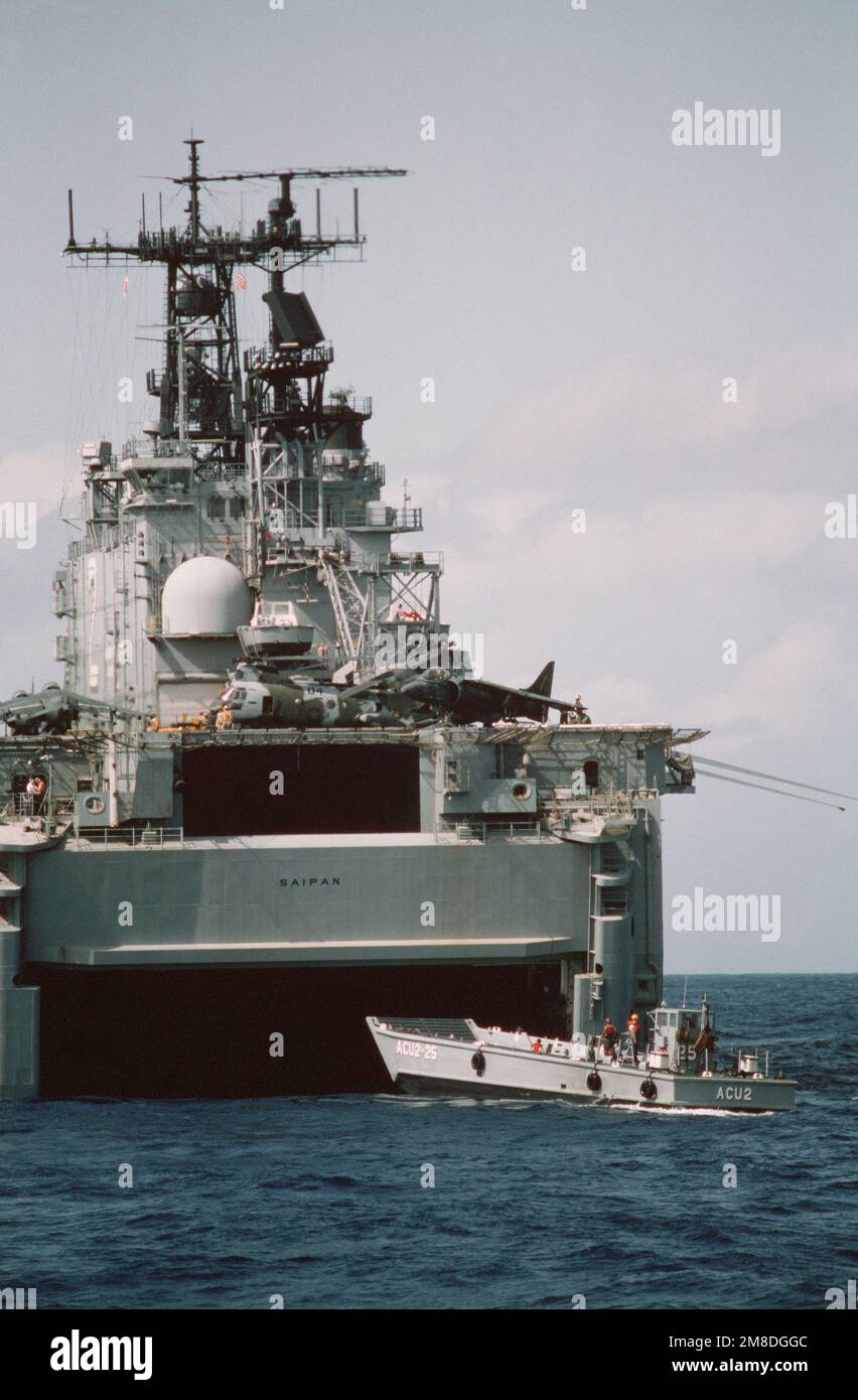 An LCM-8 mechanized landing craft backs out of the well deck of the ...