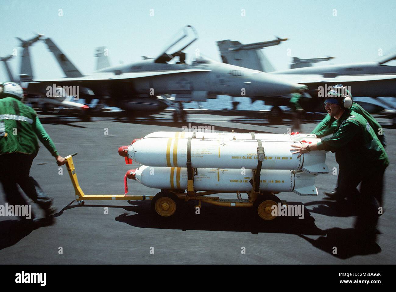 Maintenance crewmen from Attack Squadron 34 (VA-34) move a weapons skid ...