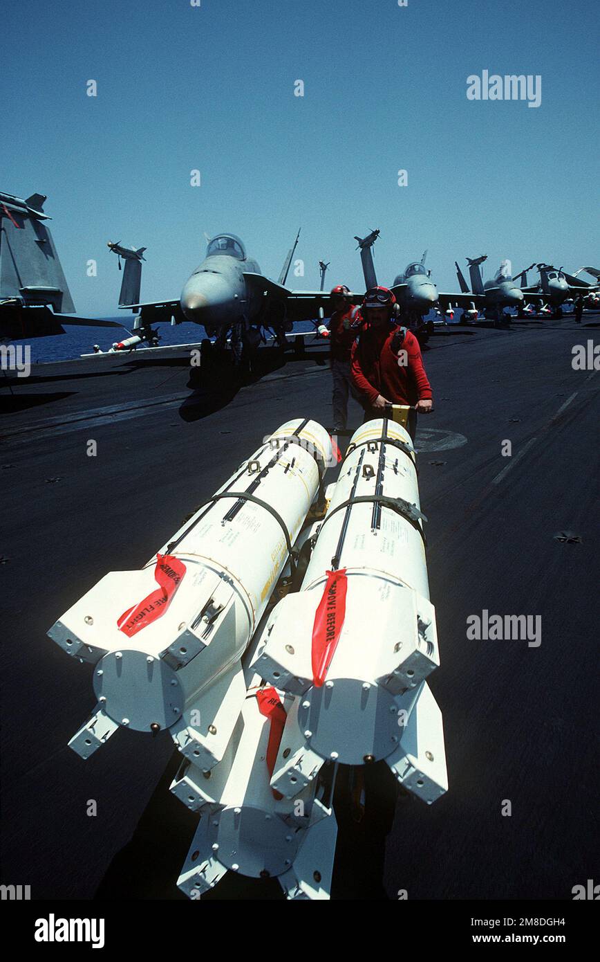 An aviation ordnanceman pulls a weapons skid loaded with Mark 20 ...