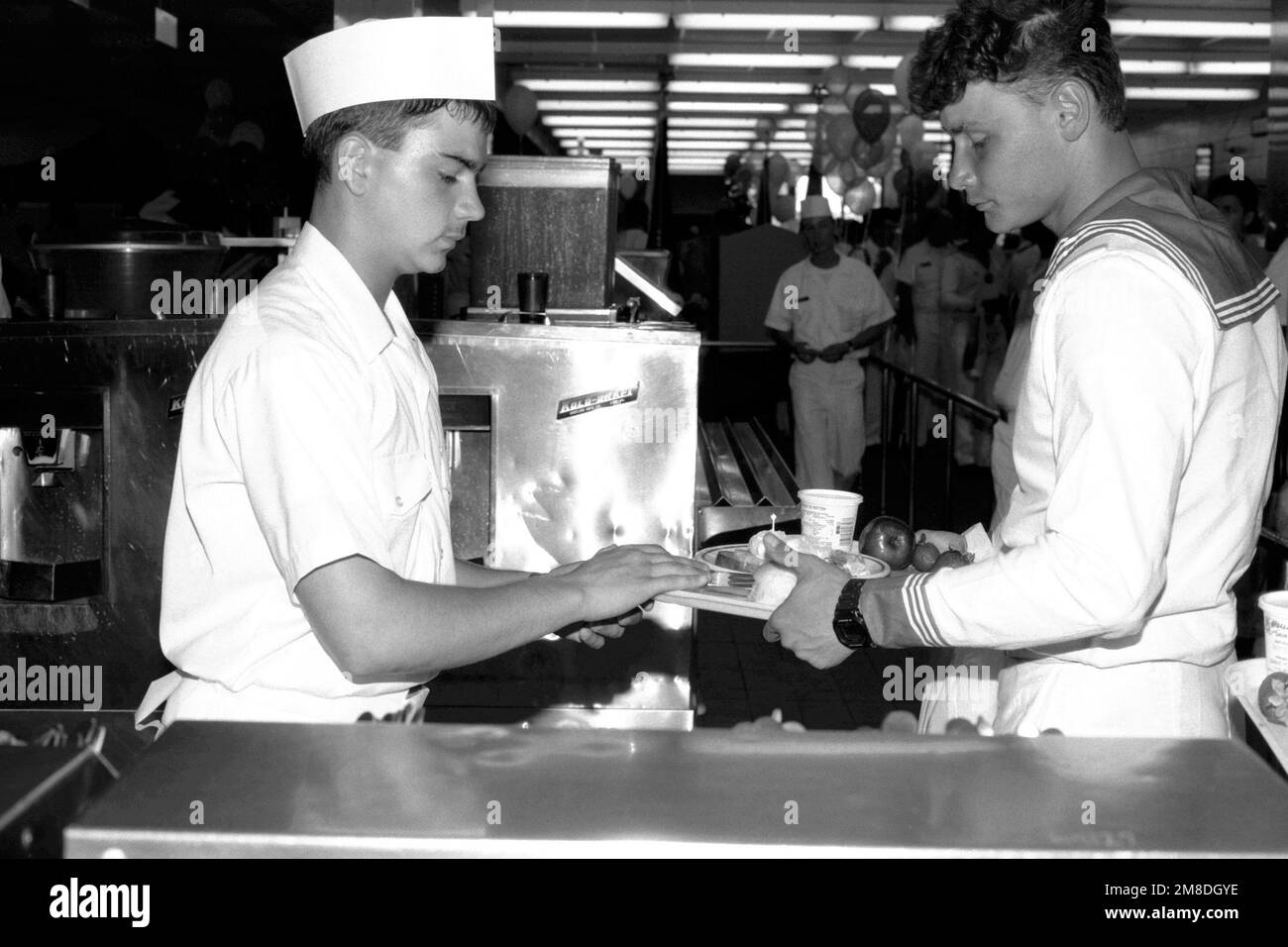 A mess management specialist gives some silverware to a Soviet sailor ...