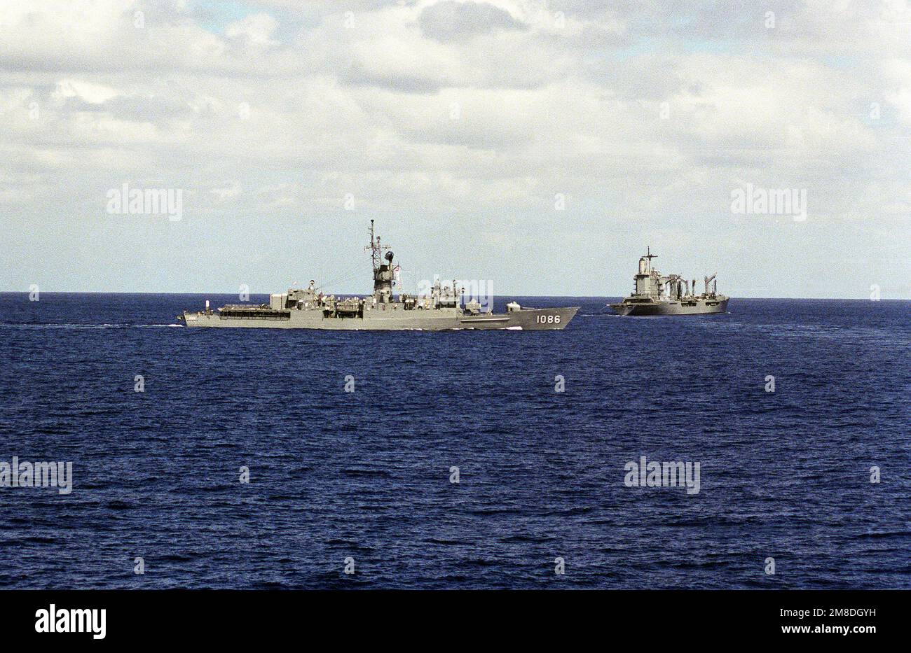 The frigate USS BREWTON (FF-1086) passes off the stern of the oiler USS ...