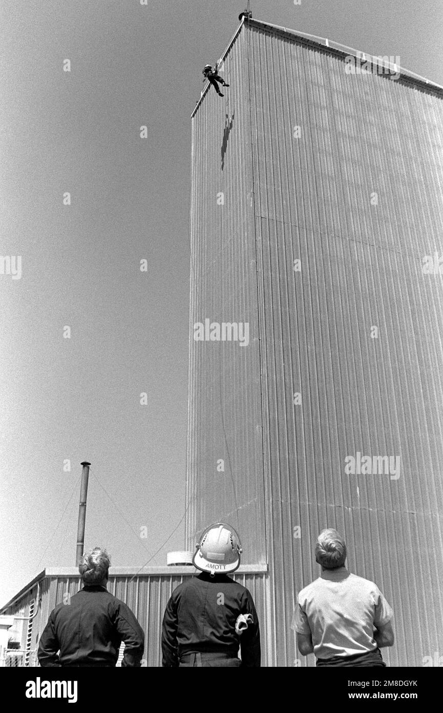 Three of his co-workers watch as firefighter Bud Robinson rappels from ...