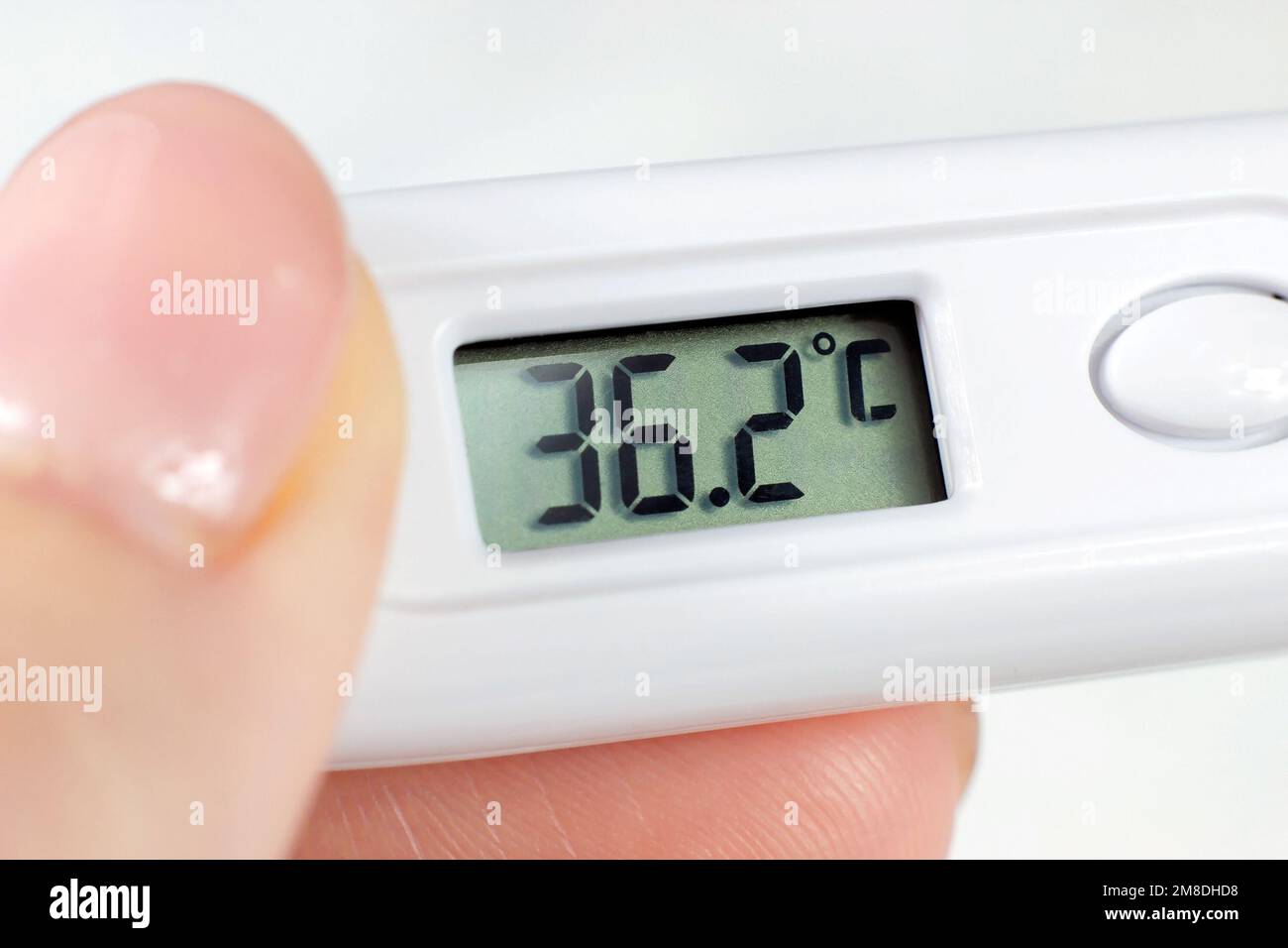Woman hands holding a white thermometer with normal body temperature ...