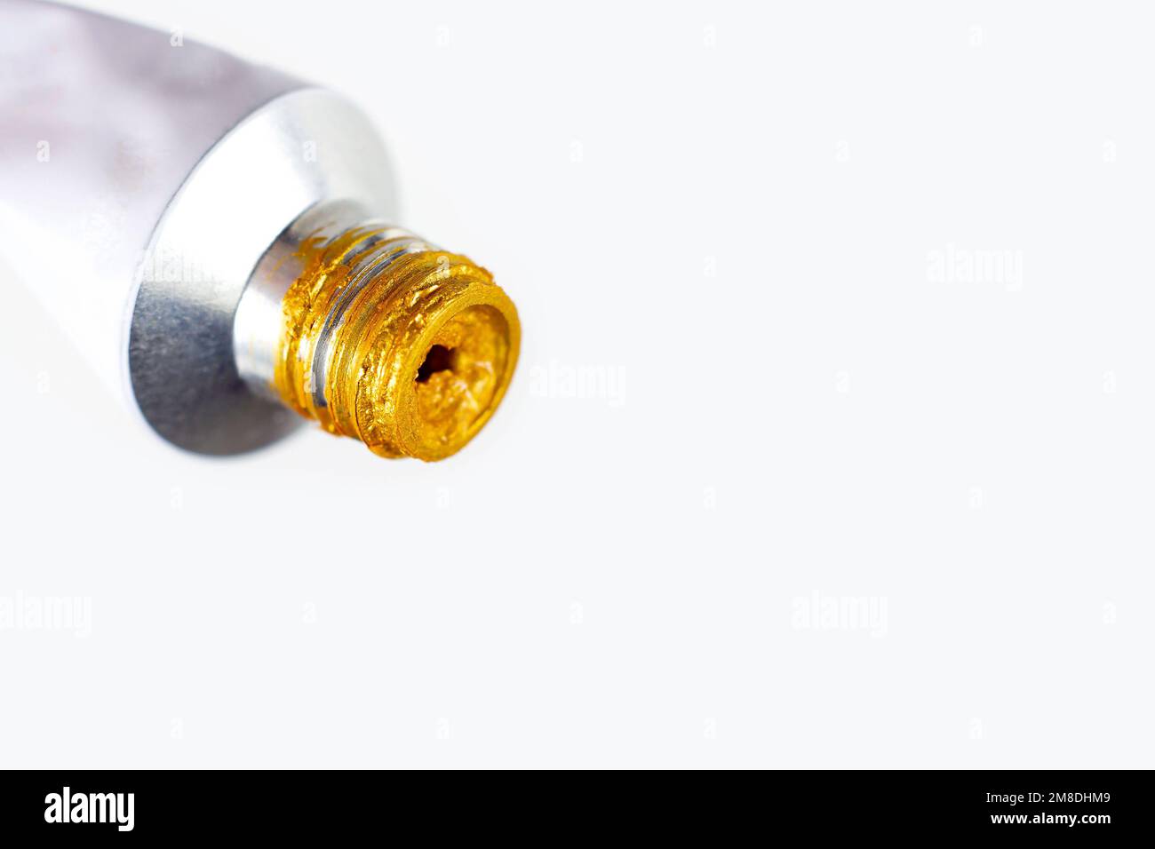 Metal acrylic tube with golden paint for drawing close up on white ...