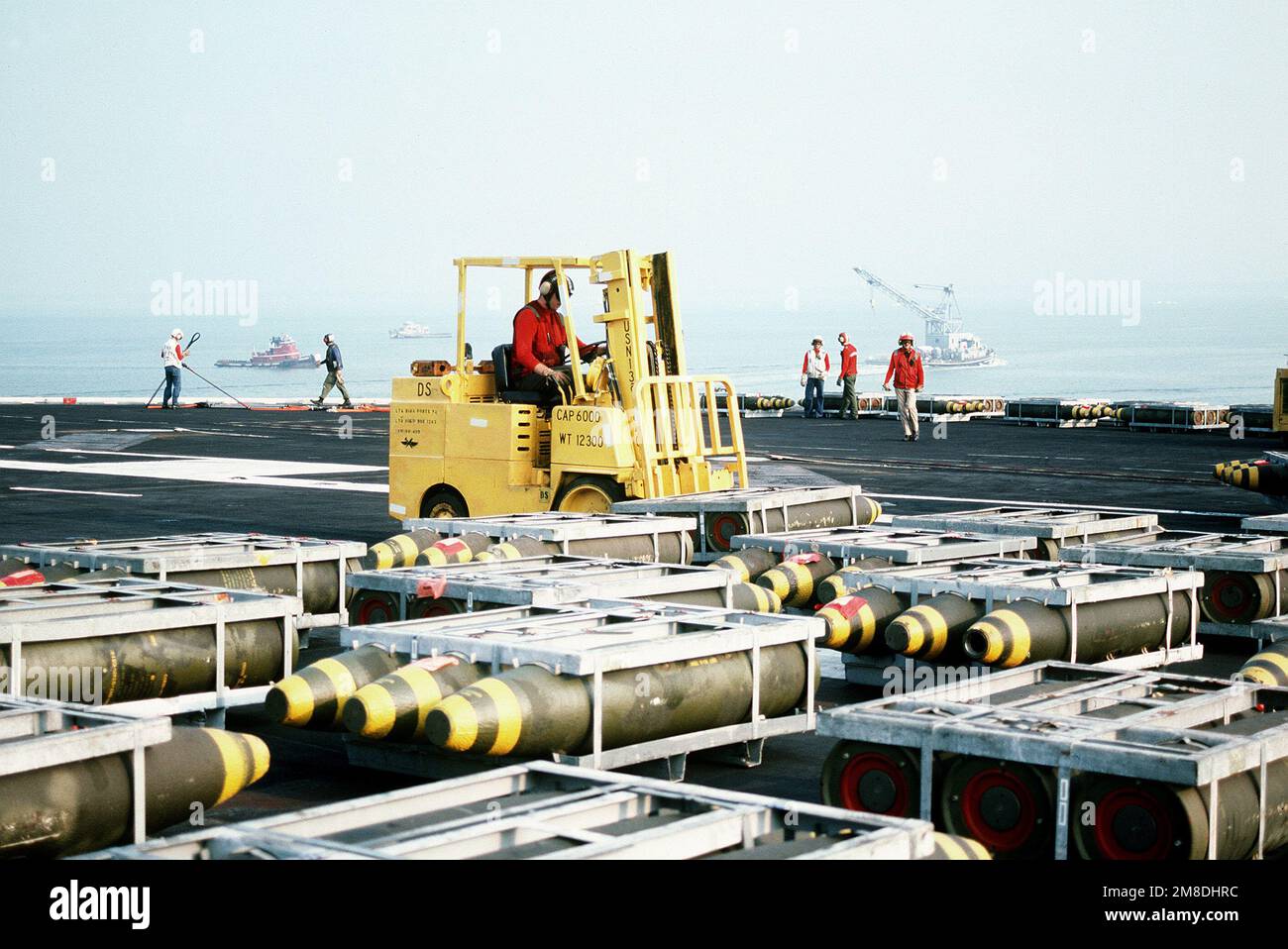A forklift positions pallets of 500-pound bombs aboard the aircraft ...