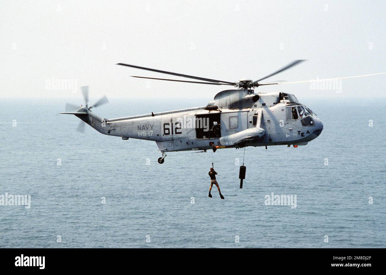 A rescue swimmer is lowered from a Helicopter Anti-submarine Squadron ...
