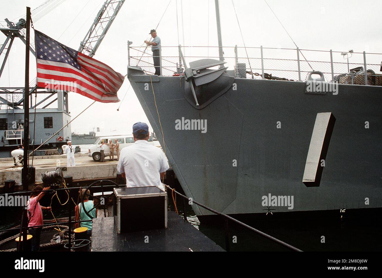 A crewman aboard the USS AVENGER (CMC-1) retrieves a messenger line ...