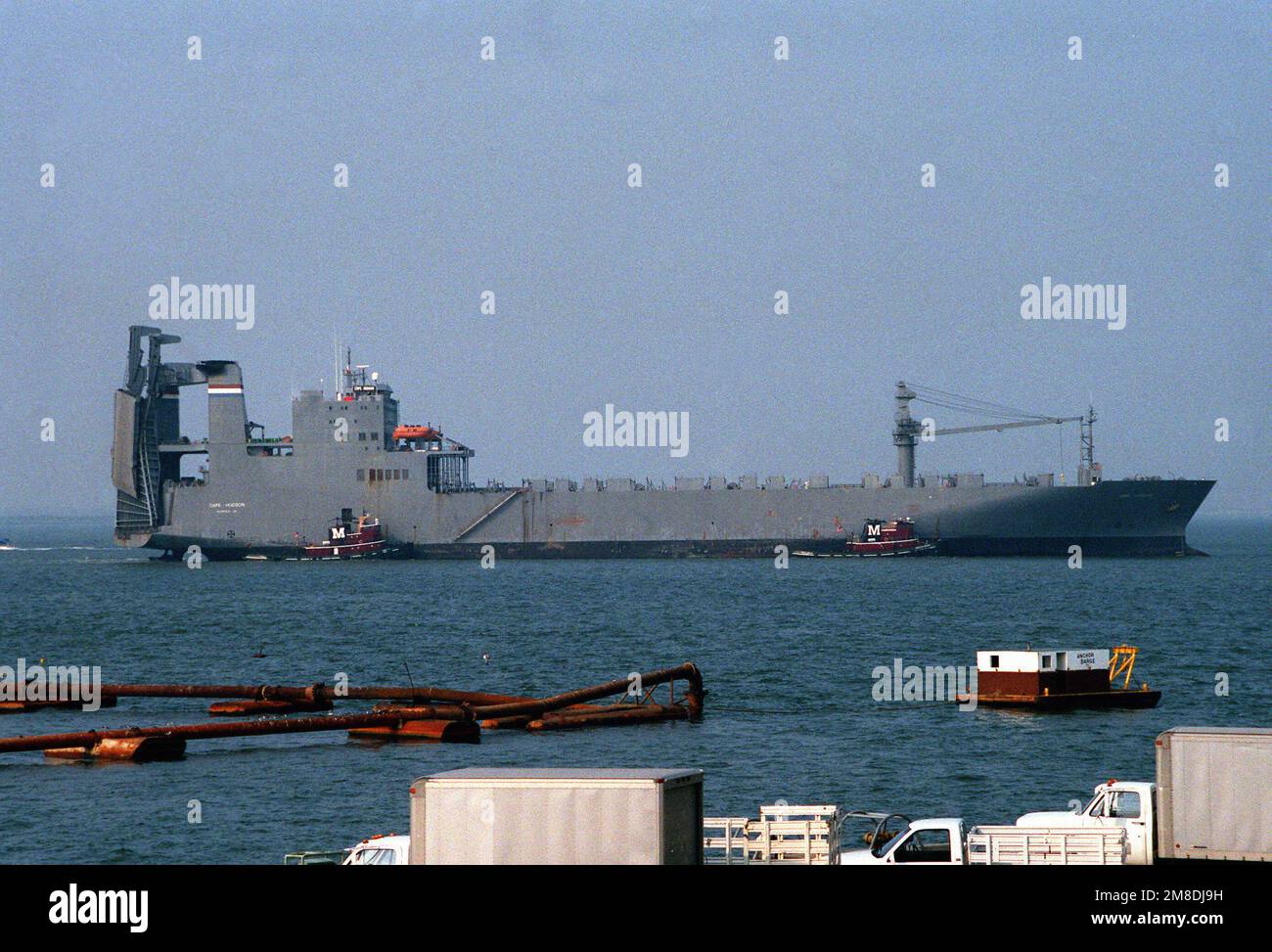 Commercial tugs maneuver the Military Sealift Command-chartered ...
