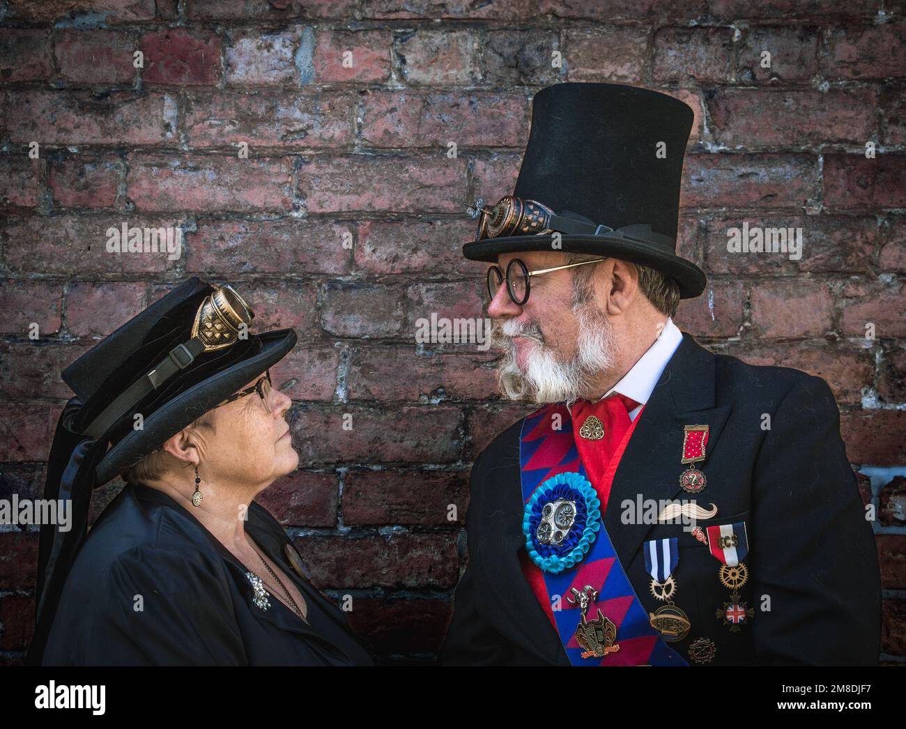 Portrait of a male and female steampunk looking into each others eyes ...