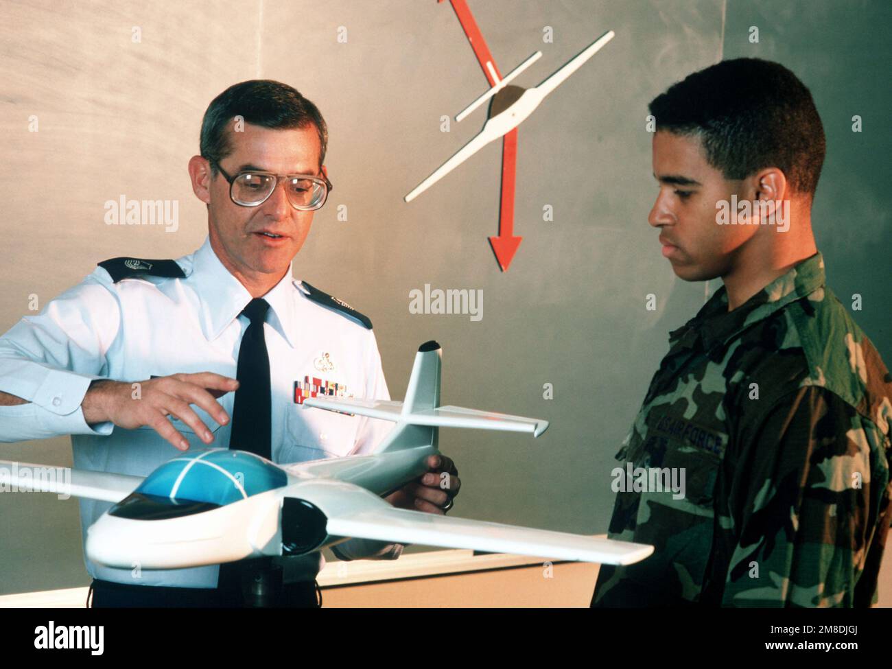 SMSGT Gary Thomas, left, holds a model of a T-37 Tweet aircraft as he ...