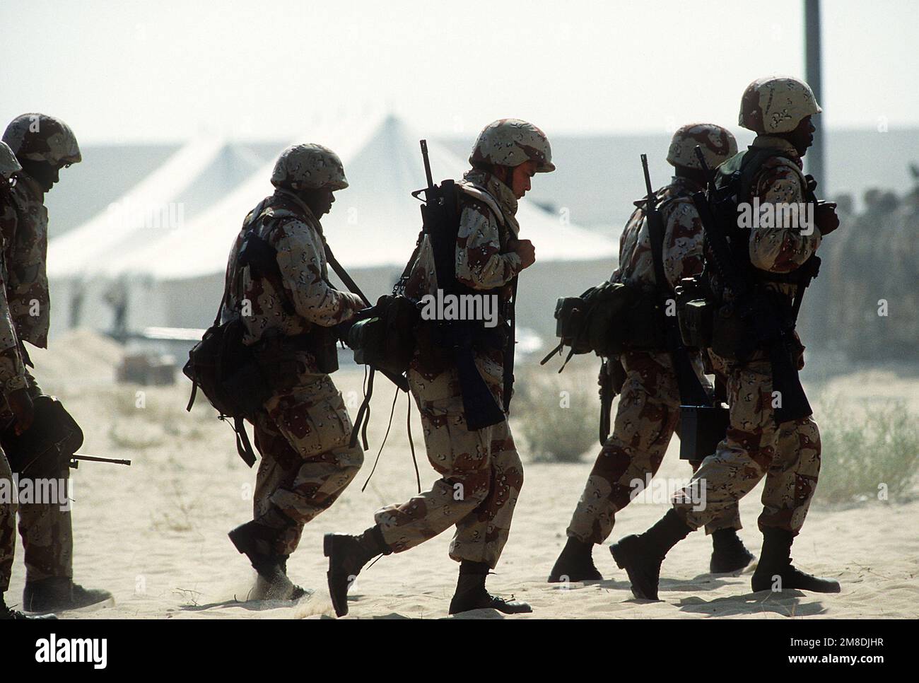 Newly arrived troops march to a processing area after disembarking from ...