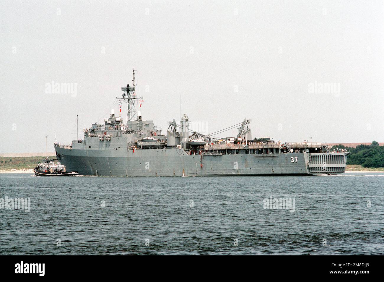 The large harbor tug CAMPTI (YTB-816) escorts the dock landing ship USS ...