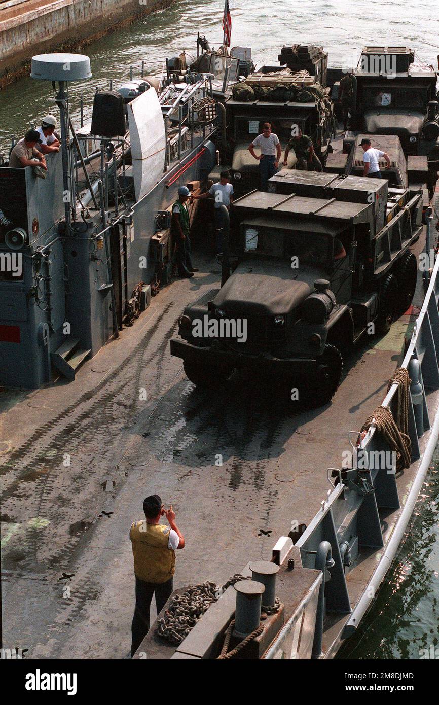 A crewman signals to the driver of an M-817 5-ton dump truck on a 1610 ...