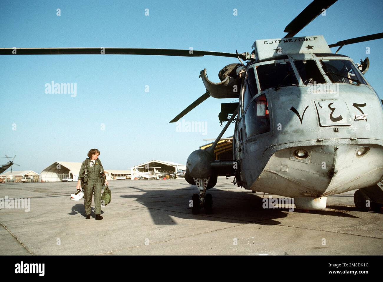 A helicopter crew member passes a Helicopter Combat Support Squadron 2 ...