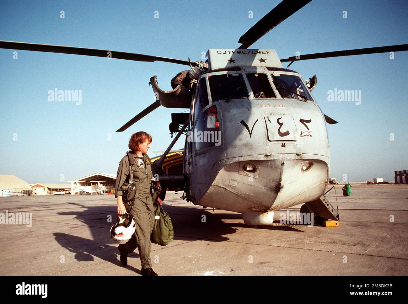 A helicopter crew member passes a Helicopter Combat Support Squadron 2 ...