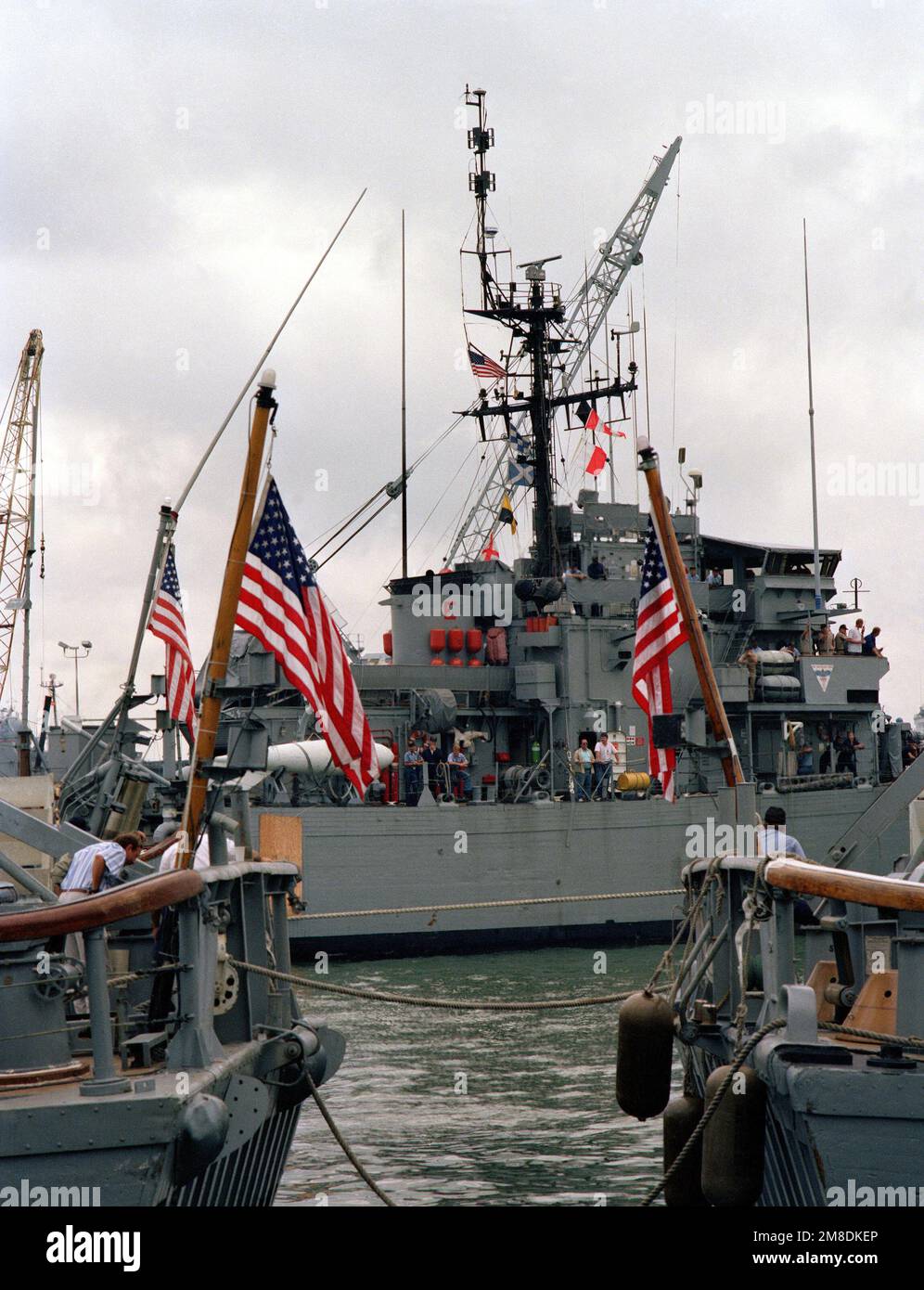 Two U.S. Navy ocean minesweepers, foreground, lie tied up over the ...