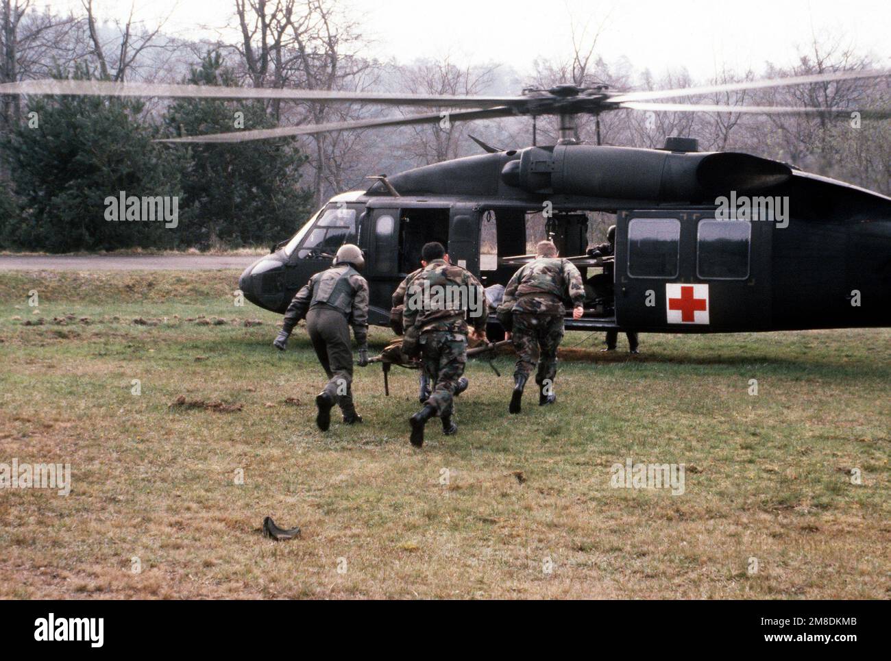 A simulated casualty is carried to a UH-60A Black Hawk (Blackhawk ...
