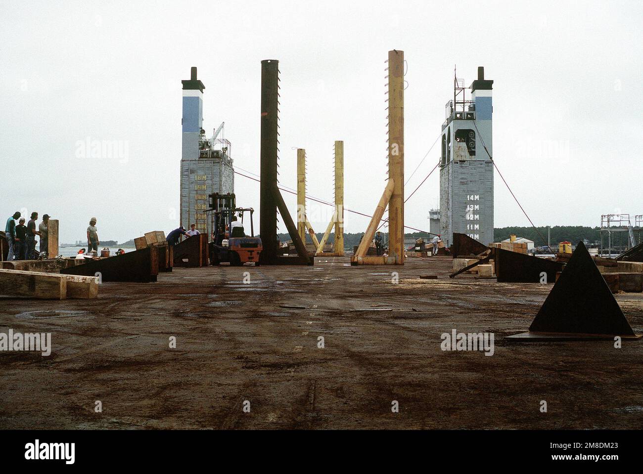 Crew members position blocks on the deck of the heavy lift ship SUPER ...