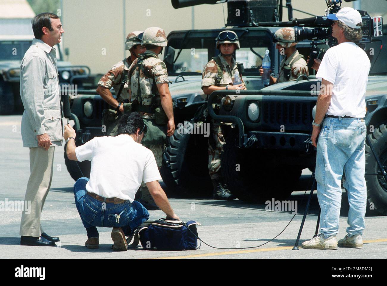 U.S. military personnel stand by M-998 multi-purpose wheeled vehicles ...