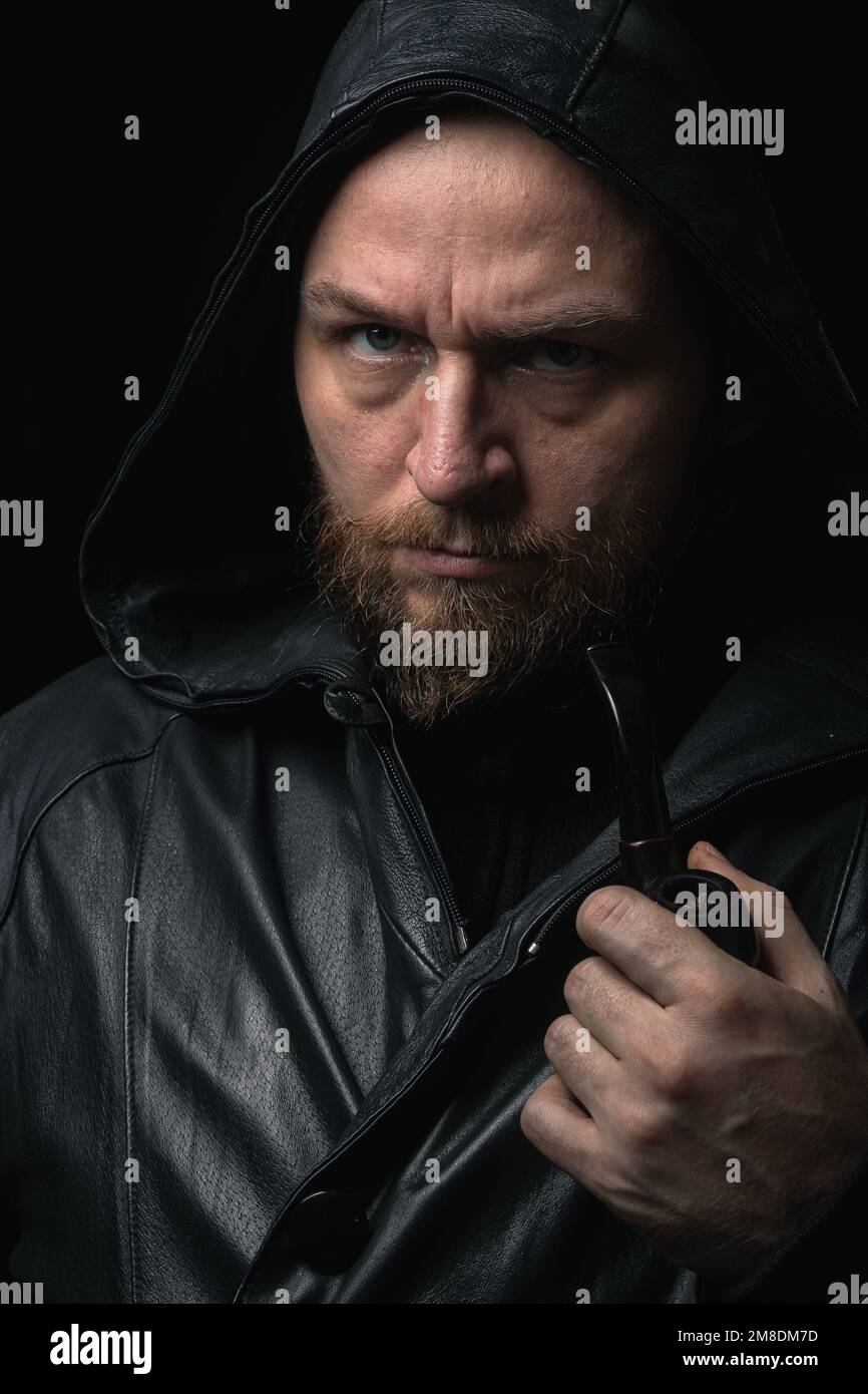 Portrait of a Bearded man in Black Rain Jacket Smoking a Pipe Stock ...