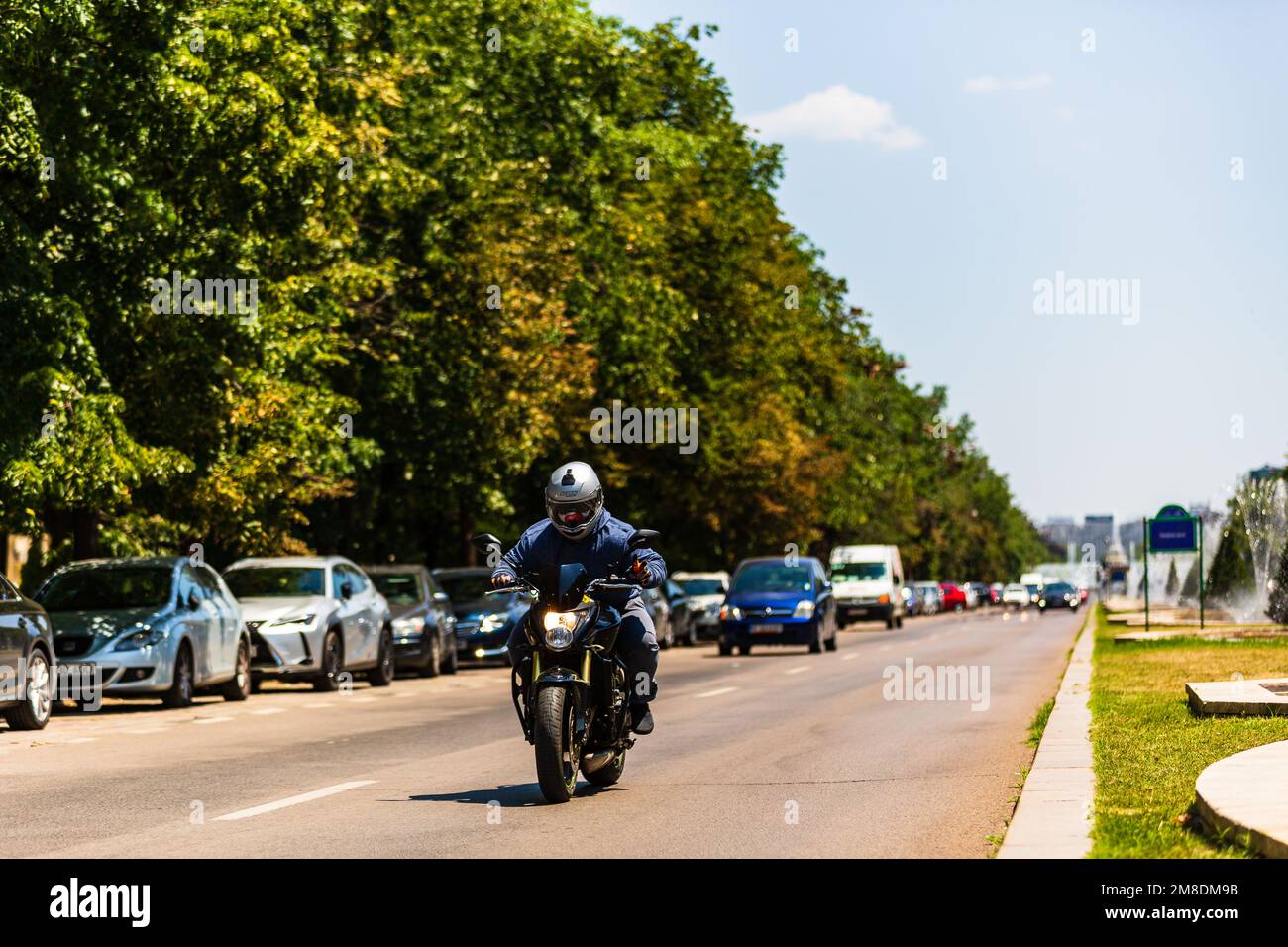 Biker on a motorcycle in traffic at rush hour in downtown area of the ...