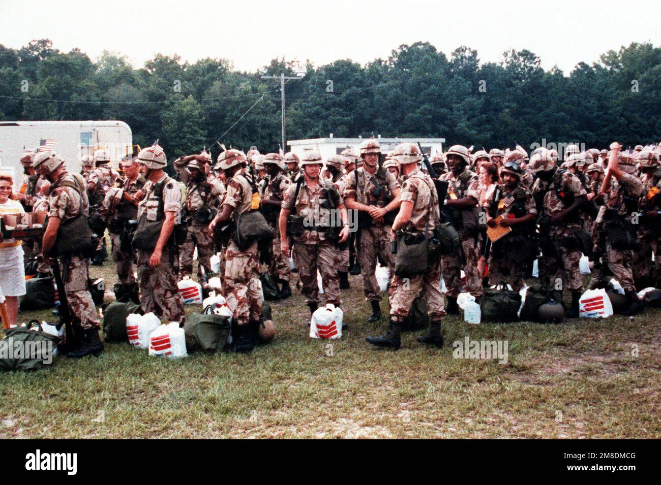 Soldiers from the 24th Infantry Division (Mechanized) wait to board an ...