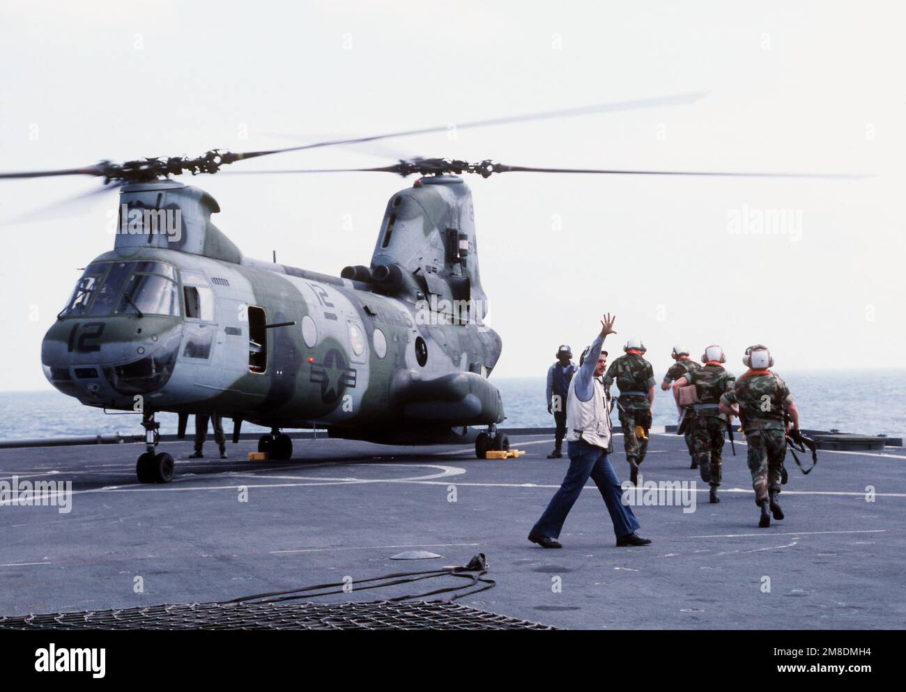 Four Marines rush across the flight deck of the dock landing ship USS ...