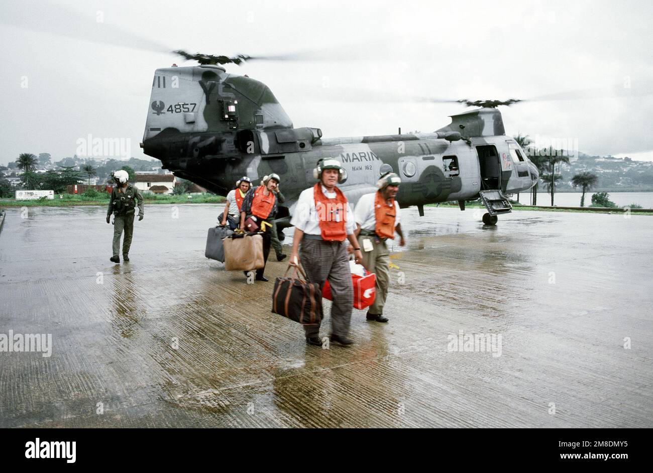 Four civilians disembark from a Marine Medium Helicopter Squadron 162 ...