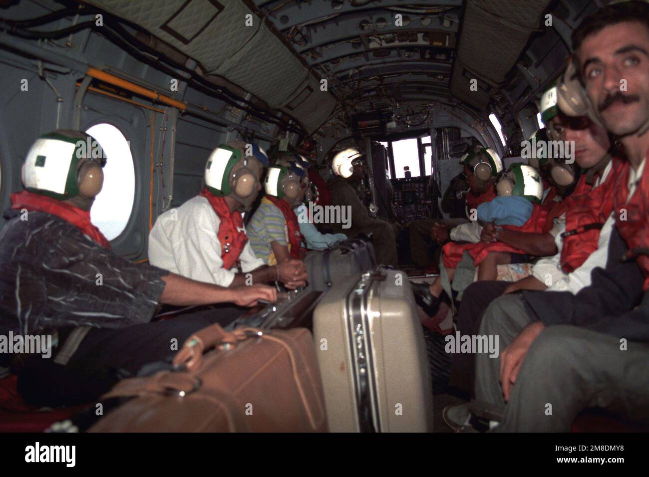 Evacuees sit aboard a Marine Medium Helicopter Squadron 162 (HMM-162 ...
