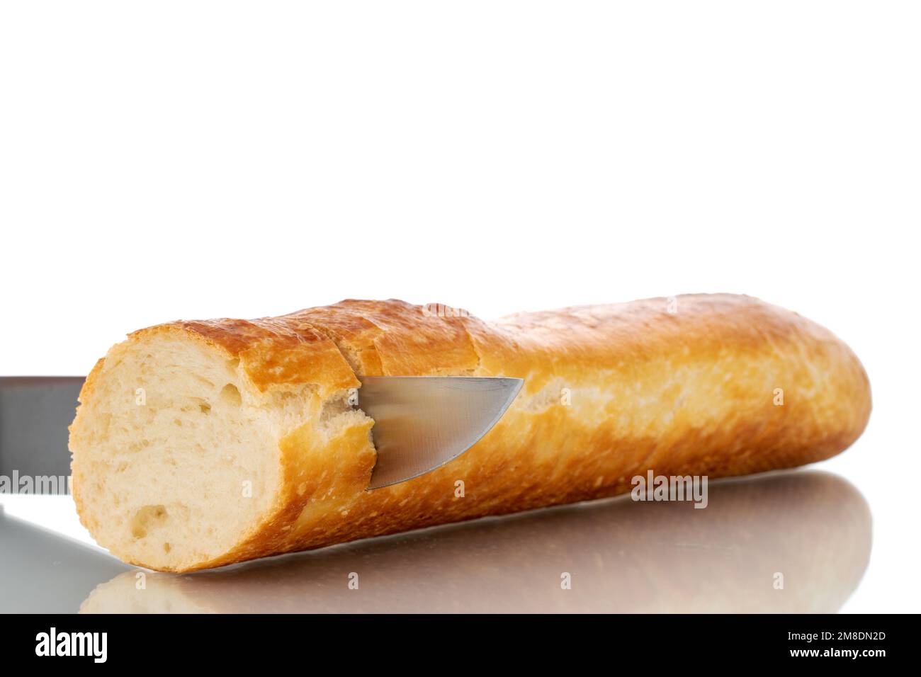 One half of fresh aromatic baguette with metal knife, macro, isolated ...