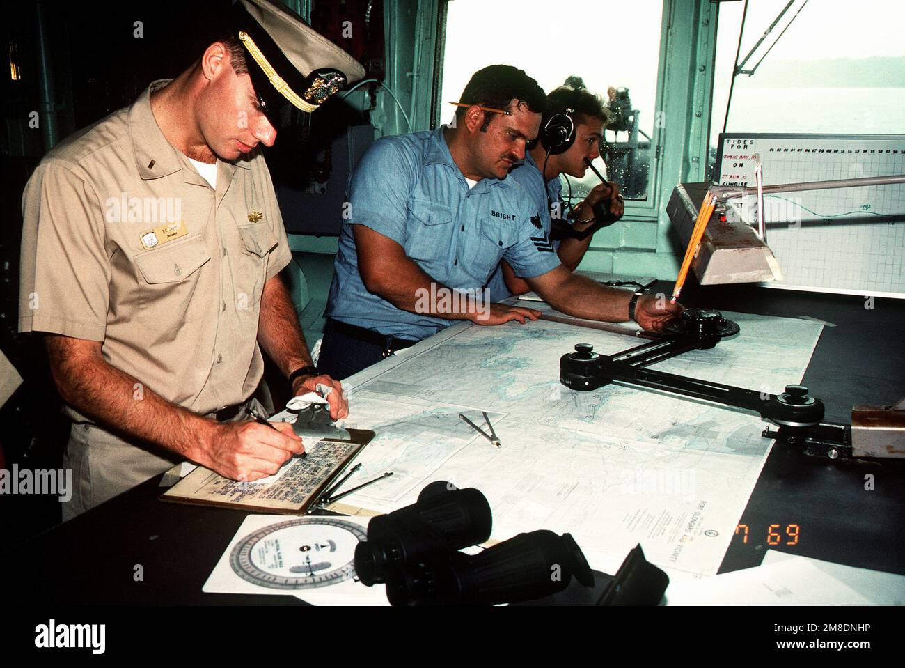 A navigation team plots the ship's course aboard the amphibious ...