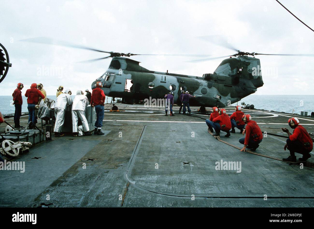 Flight deck crewmen stand by as a Marine Medium Helicopter Squadron 162 ...