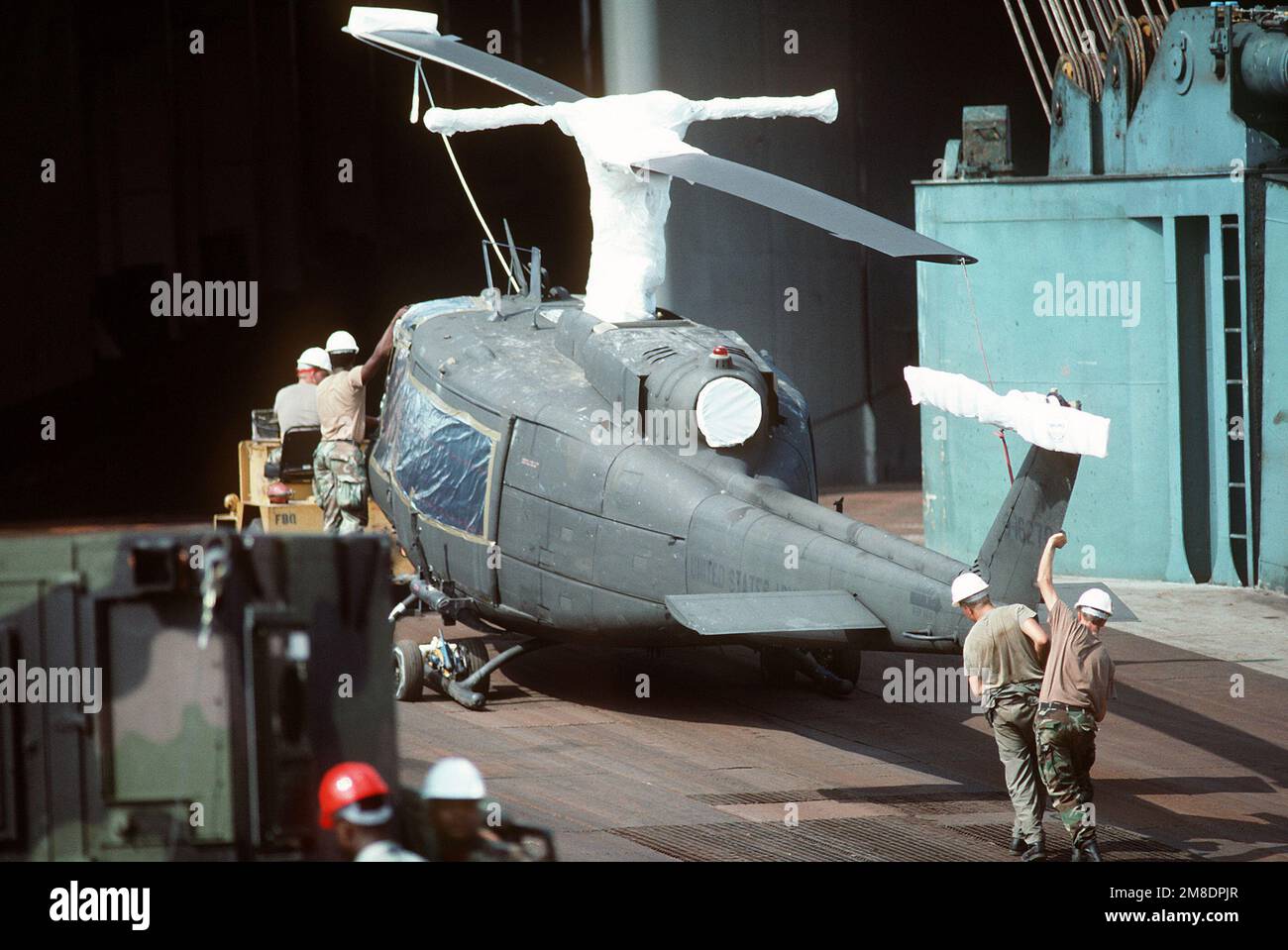 Soldiers of the 1181st Transportation Terminal Unit help push a UH-1H ...