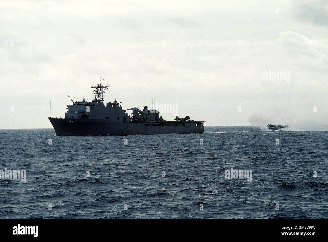 An air cushion landing craft (LCAC) approaches the stern of the dock ...