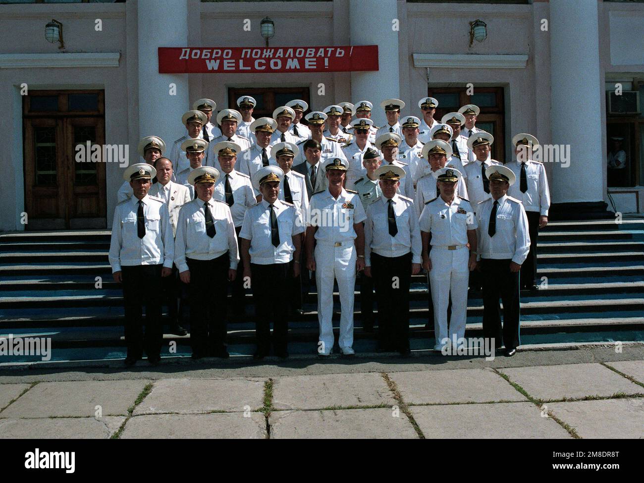 Americans and their Soviet hosts gather in front of a Soviet navy ...