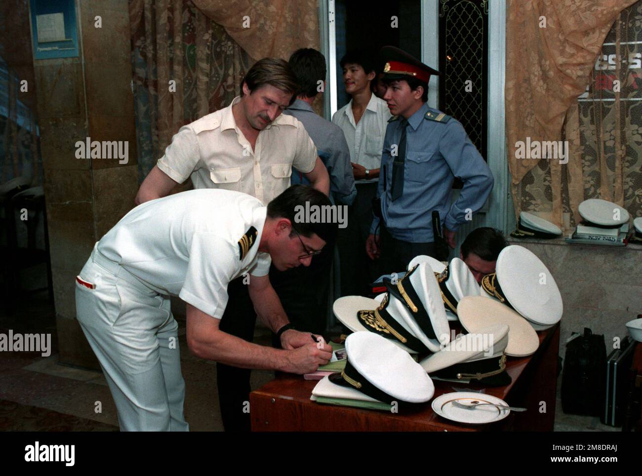 A US Navy officer autographs a Polaroid photograph for a Soviet man ...