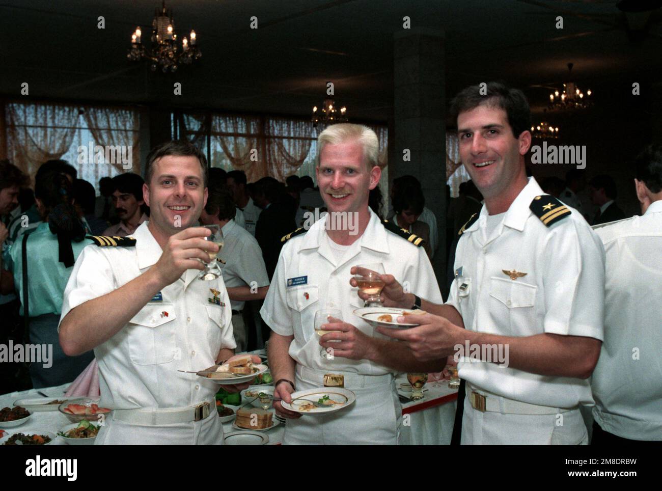 Three US Navy officers attend a reception during a visit to the city by ...
