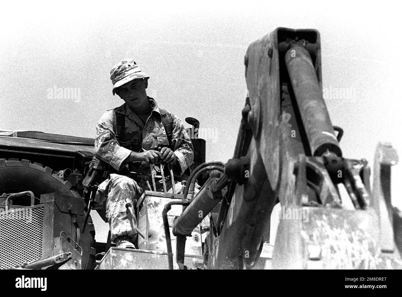 A Marine uses the backhoe on the rear of a small emplacement excavator ...