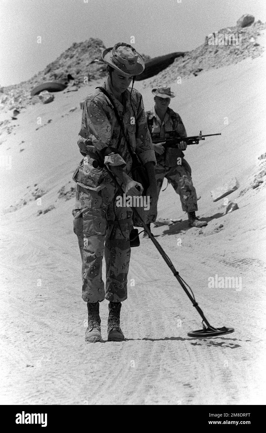 A Marine uses a hand-held mine detector while taking part in an ...