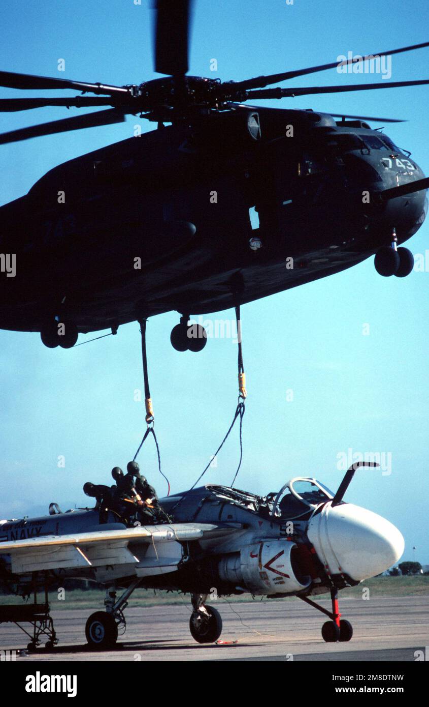 Members of a helicopter support team hook up a damaged Attack Squadron ...
