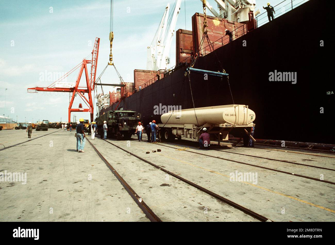 Longshoremen attach lifting cables to an M-131 5,000-gallon fuel tank ...