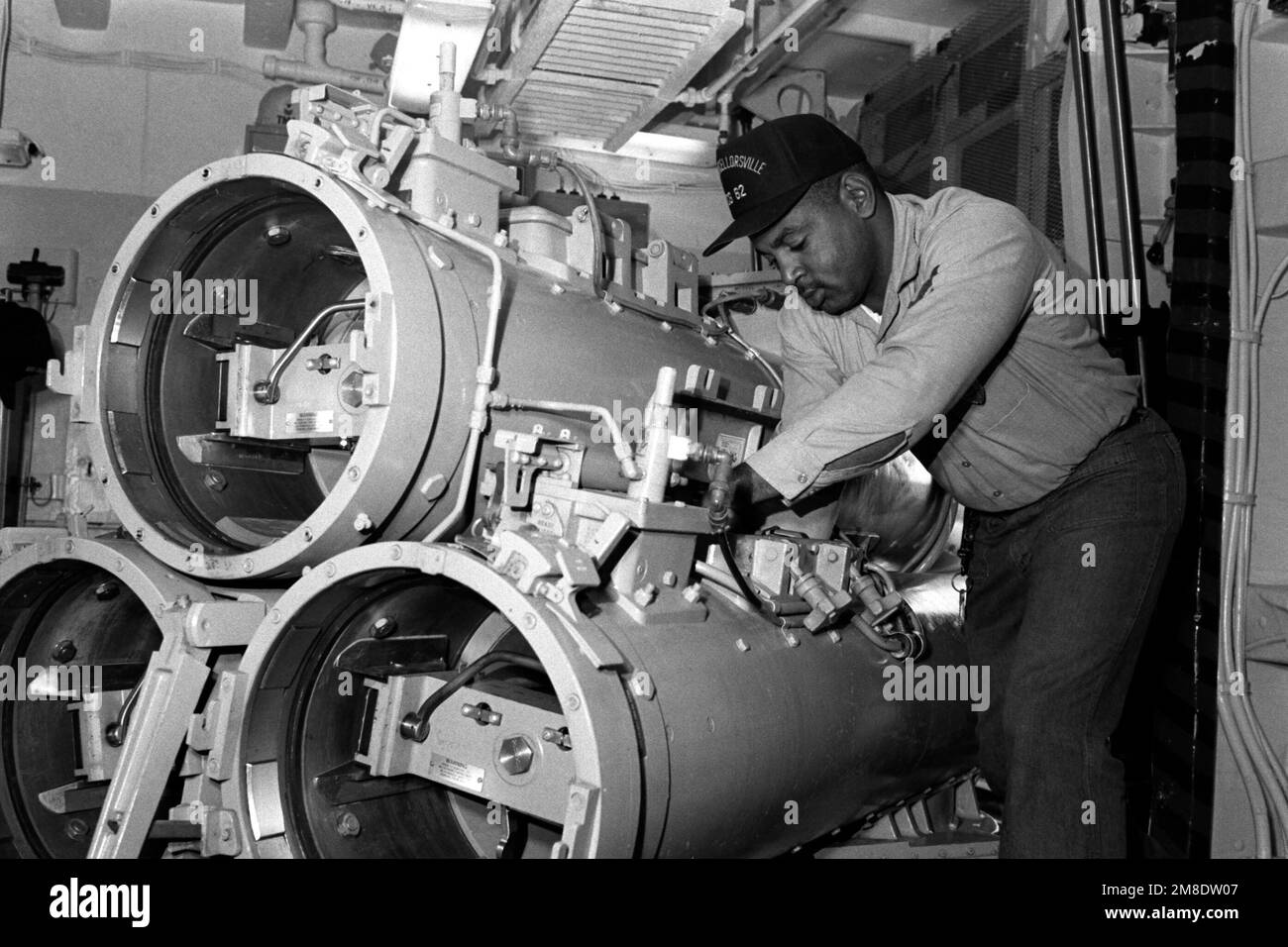 Torpedoman's Mate 1ST Class Ralph Betts inspects connections on one of ...