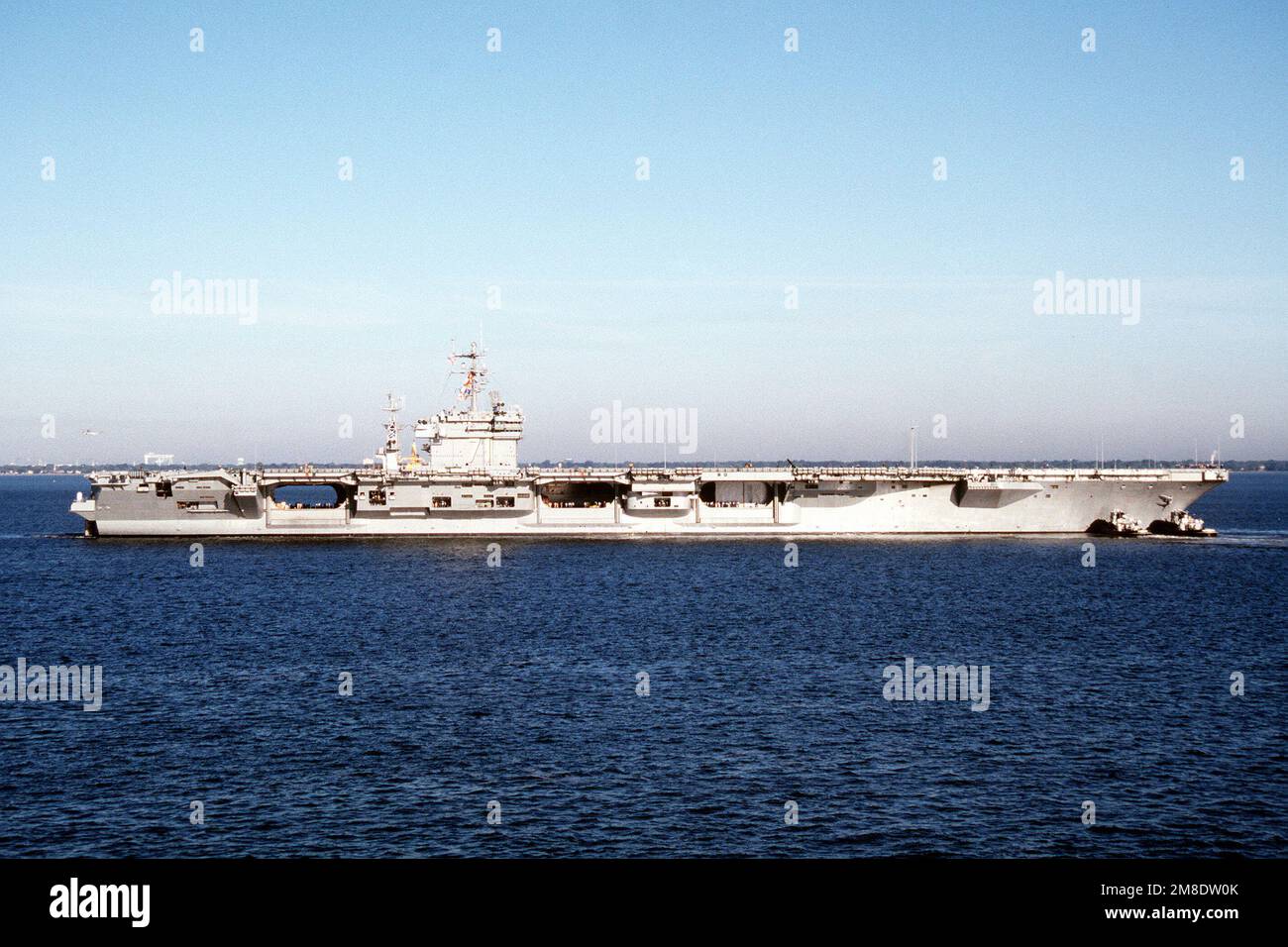 Two U.S. Navy large harbor tugs assist the nuclear-powered aircraft ...