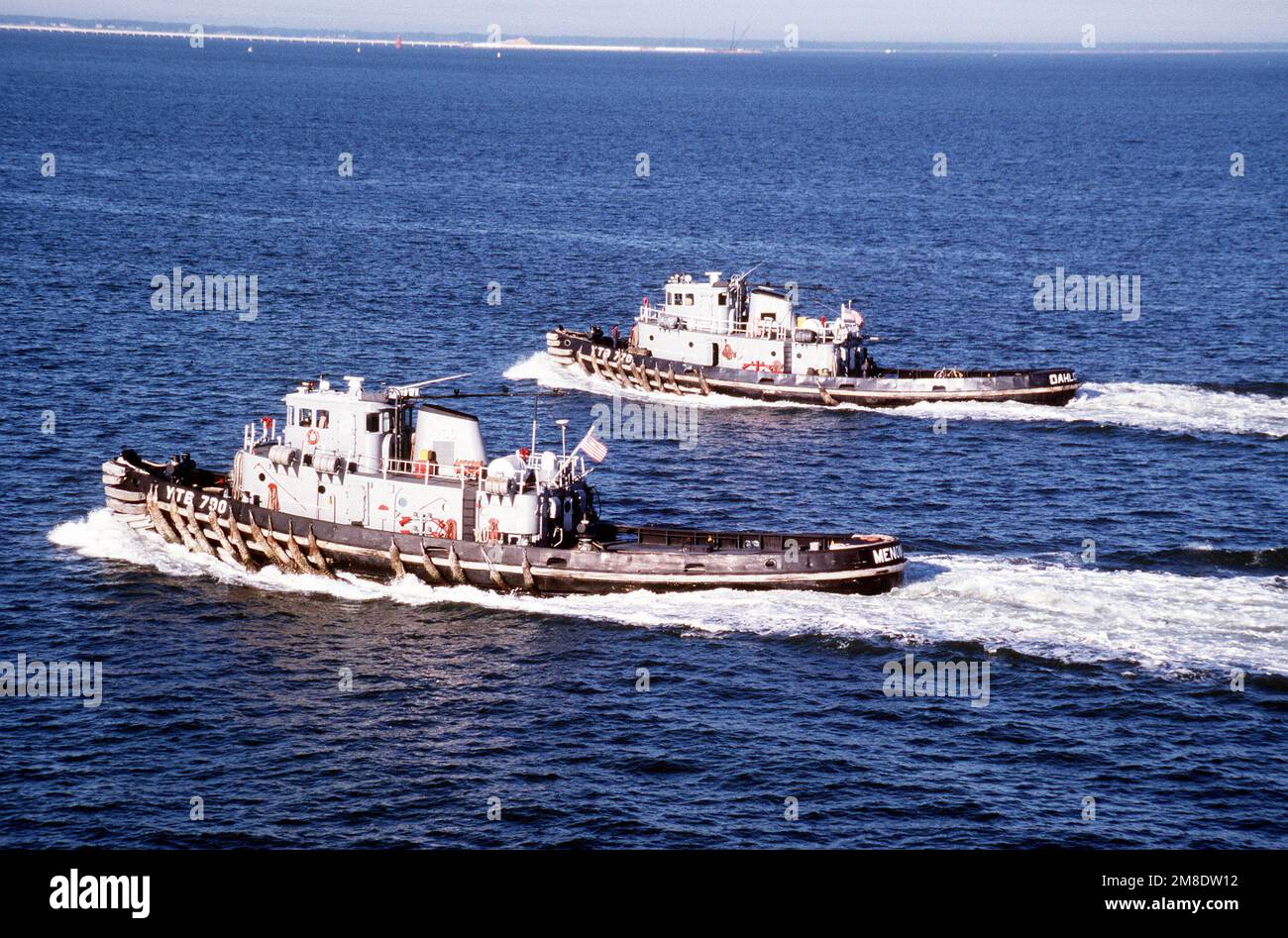 A port view of the large harbor tugs MENOMINEE (YTB-790), foreground ...
