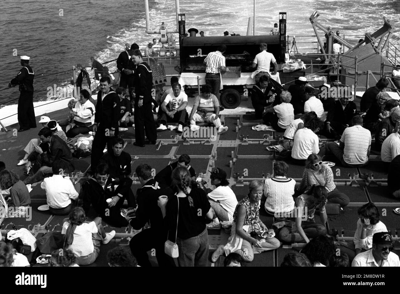 Sailors and their families eat a picnic lunch aboard the guided missile ...