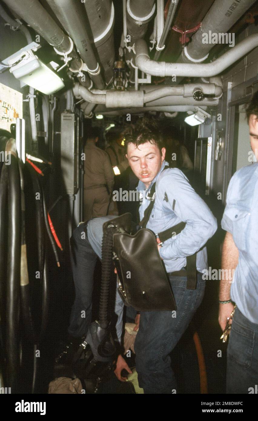 A member of a repair party removes his oxygen breathing apparatus (OBA ...