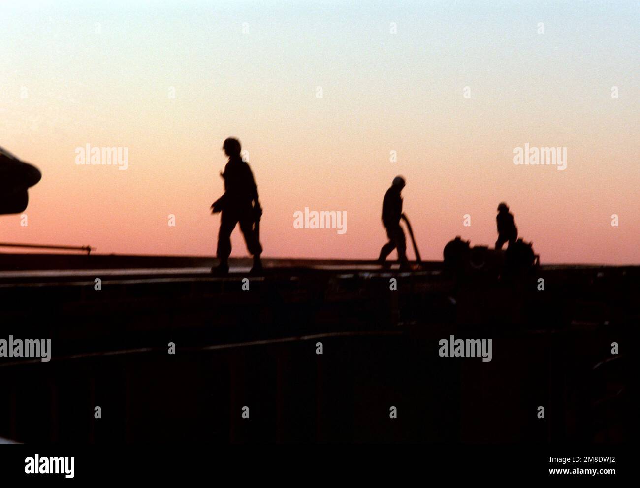 Crewmen perform maintenance on a catapult track on the flight deck of ...