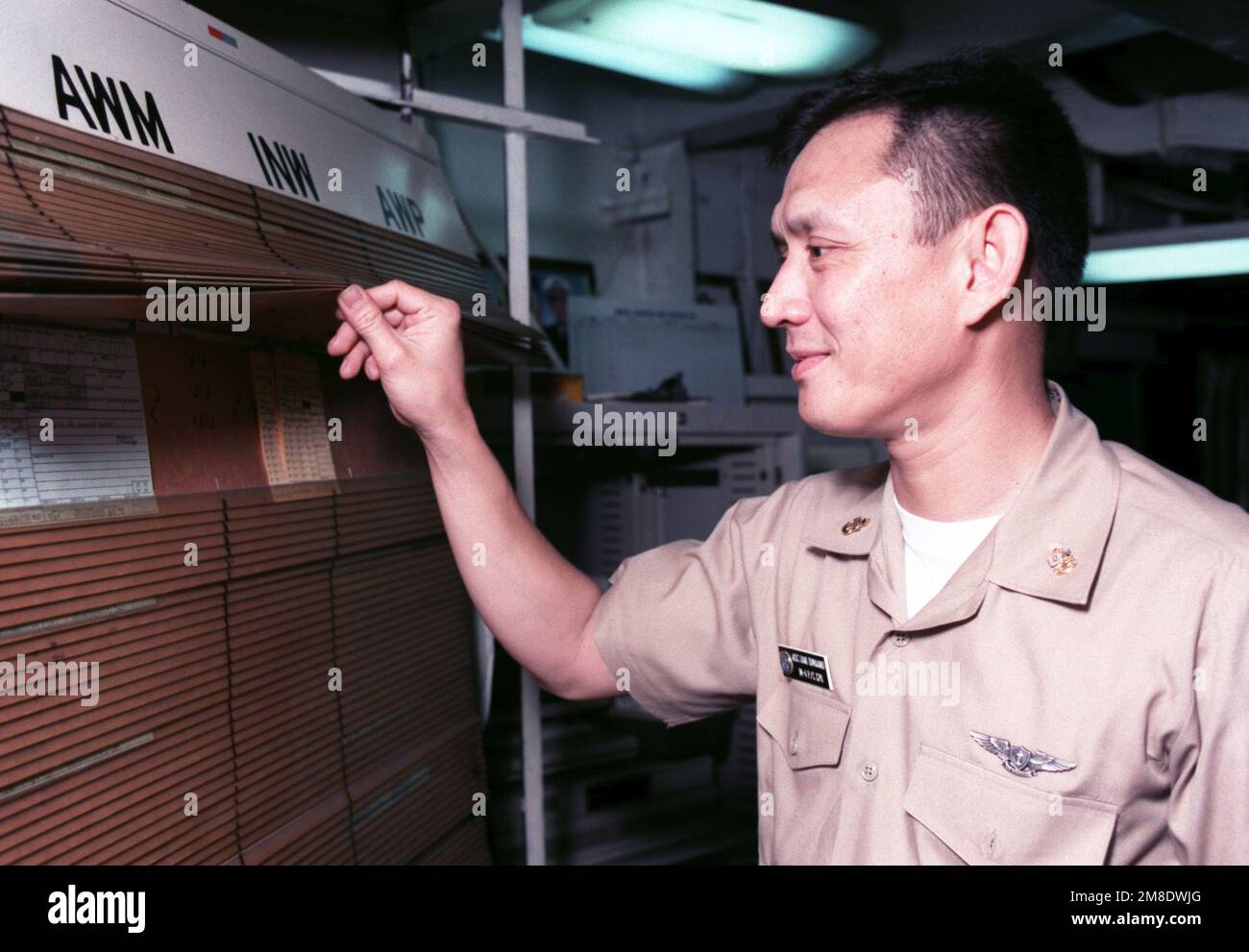 A chief petty officer checks a maintenance record in an Aircraft ...