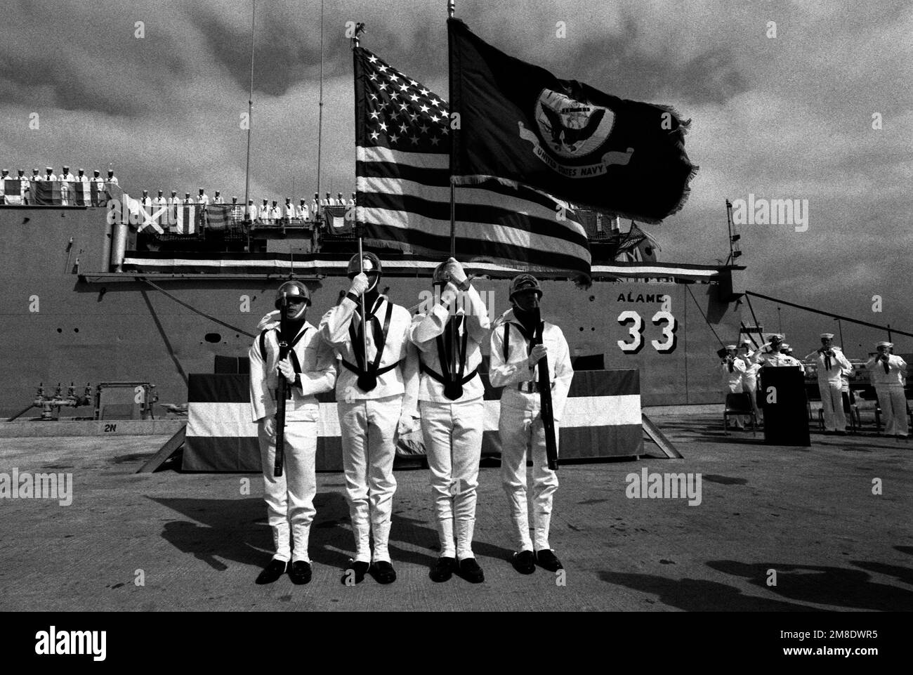 Crew members man the rails aboard the dock landing ship USS ALAMO (LSD ...